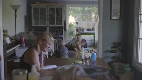 Mother Sitting at Table Reading with Fou... | Stock Video | Pond5