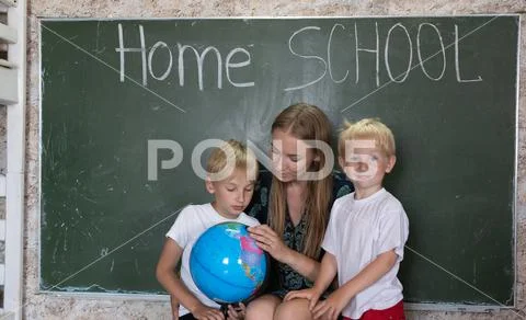 Mother is studying a world map on a globe with her children. Stock ...