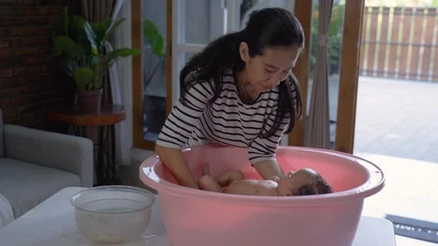 mother taking a bath of her infant baby ... | Stock Video | Pond5