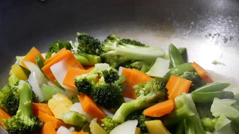 Motion of woman cooking vegetable in a p... | Stock Video | Pond5