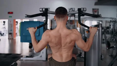 The muscular man pumps his back muscles ... | Stock Video | Pond5