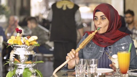 Muslim veiled woman smoking shisha at Na... | Stock Video | Pond5