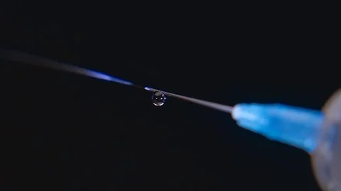 From the needle of the plastic syringe a... | Stock Video | Pond5