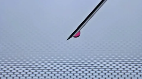 With a needle from the syringe flows a d... | Stock Video | Pond5