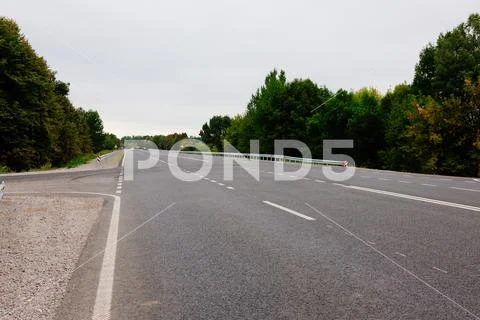 New asphalt road with markings and road signs in the sun's rays Photo ...
