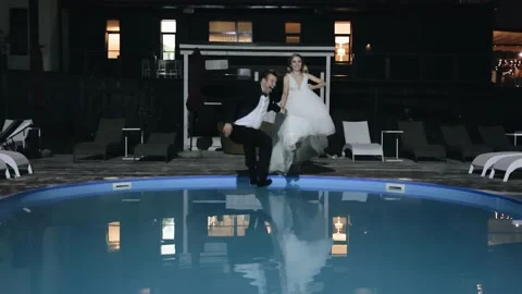 The newlyweds jump into the pool with wa... | Stock Video | Pond5