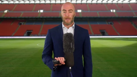 A news reporter in a soccer stadium repo... | Stock Video | Pond5