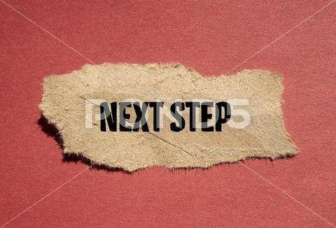 Photograph: Next step words written on torn paper piece with red ...