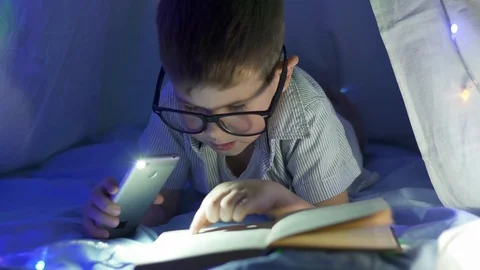 night reading, cute child in eyeglasses ... | Stock Video | Pond5