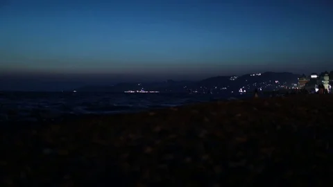Night sea shore with distant city lights... | Stock Video | Pond5