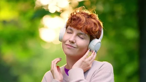 Non-binary gender person listening to mu... | Stock Video | Pond5
