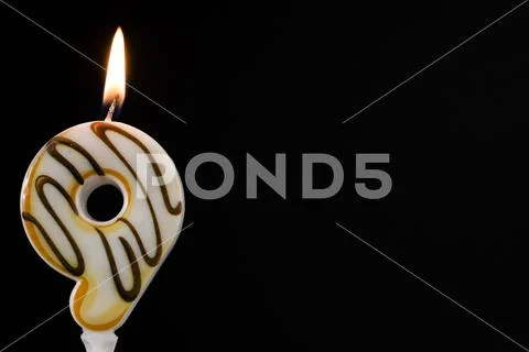 Number 9 birthday celebration donut candle a black background. Copy ...