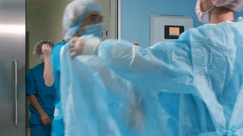 Nurse and assistant dressing surgeon gow... | Stock Video | Pond5