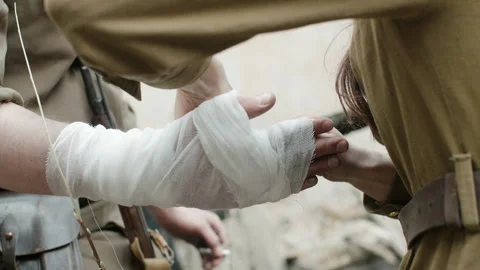 Nurse bandages a soldier's hand in the f... | Stock Video | Pond5