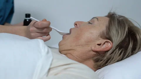 Nurse giving syrup to elderly female pat... | Stock Video | Pond5