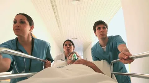 Nurses driving a patient on his bed with... | Stock Video | Pond5