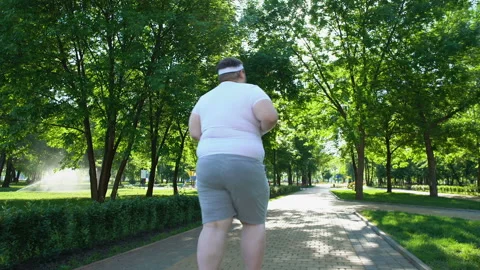 Obese man jogging in park, struggling wi... | Stock Video | Pond5