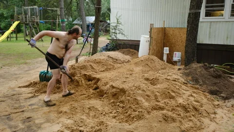 Obese man shoveling pile of sand into wa... | Stock Video | Pond5