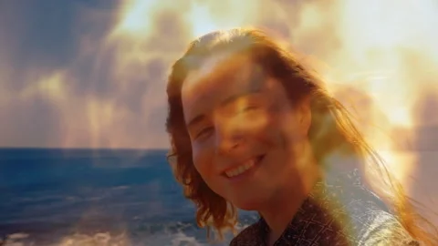 By ocean, person smiling with warm, glow... | Stock Video | Pond5