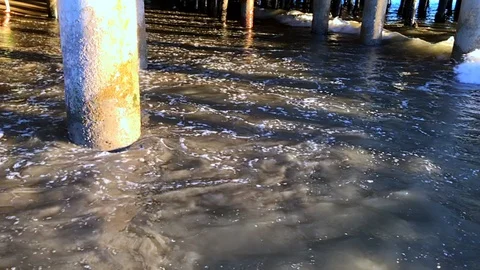 Ocean waves goes between the pillars on ... | Stock Video | Pond5