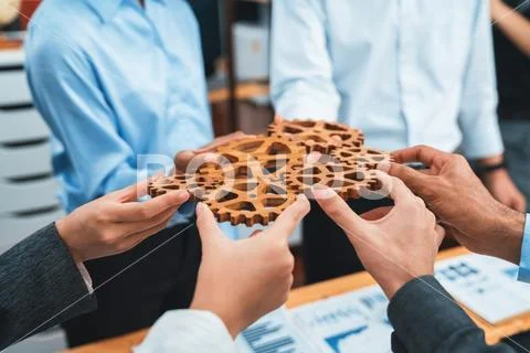 Office worker holding cog wheel as unity and teamwork in workplace ...