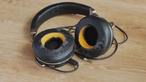Old broken headphones close-up on a ligh... | Stock Video | Pond5