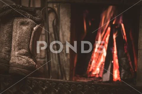Old felt boots and fireplace with warm fire on the background Stock ...
