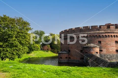 Old fortress with red brick and granite, loopholes, water moat and a ...
