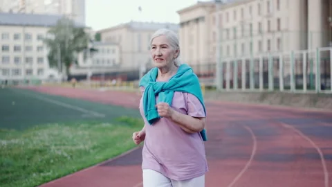 Old lady run stadium. Elderly woman jog ... | Stock Video | Pond5