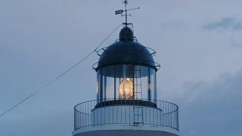 Old lighthouse is working at twilight on... | Stock Video | Pond5