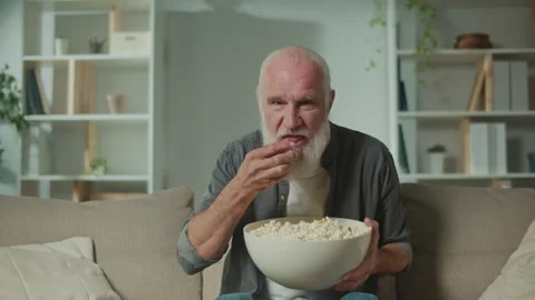 An Old Man Eating Popcorn and Concentrat... | Stock Video | Pond5