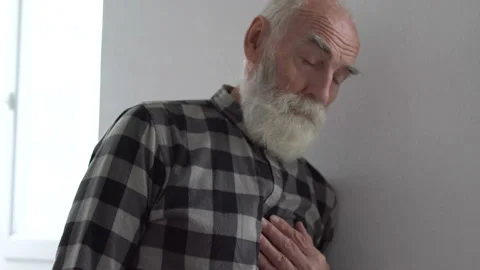 Old man falling down holding hand on che... | Stock Video | Pond5