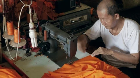 old man making an orange robe for a monk... | Stock Video | Pond5