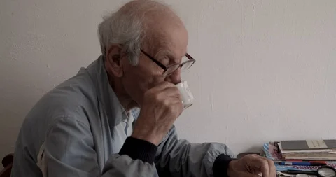 Old man sitting at the table drinking co... | Stock Video | Pond5