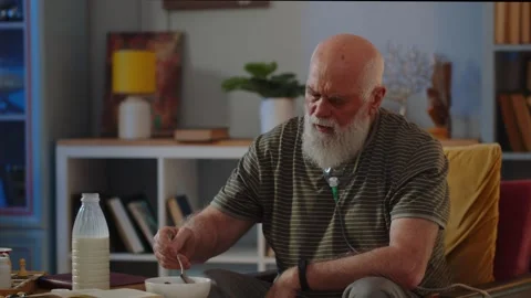 Old man stay in chair and prepare dinner... | Stock Video | Pond5