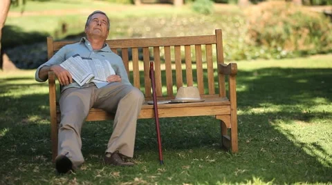Old man waking up on a bench | Stock Video | Pond5