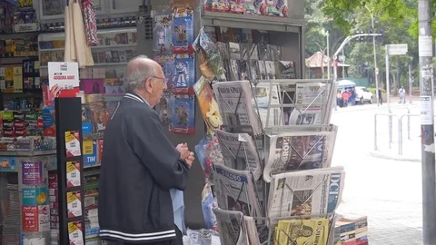 An Old Men Picking A New Paper From A St... | Stock Video | Pond5