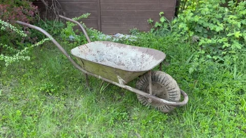 Old rusty garden wheels in the garden | Stock Video | Pond5