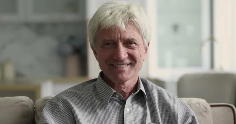 Older single man sit on sofa pose at cam... | Stock Video | Pond5