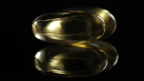 Omega 3 Gold oil capsules on black backg... | Stock Video | Pond5