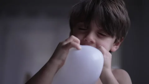 One cute little boy blowing up balloon w... | Stock Video | Pond5