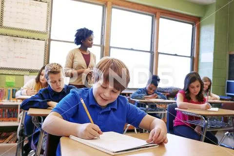 Photograph: One more question to answer...a young boy sitting in class ...