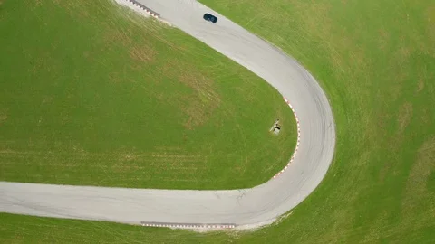 One racecar takes a sharp turn around a ... | Stock Video | Pond5