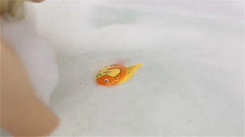 Orange plastic fish swiming in the bath.... | Stock Video | Pond5