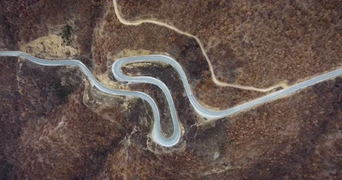 Overhead shot of car driving on a curvy ... | Stock Video | Pond5