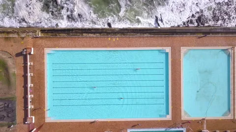 Overhead swimming pool next to the ocean | Stock Video | Pond5