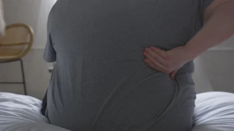 An Overweight Man Rubbing His Back and S... | Stock Video | Pond5