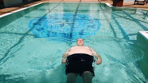 Overweight obese man swimming in hotel p... | Stock Video | Pond5