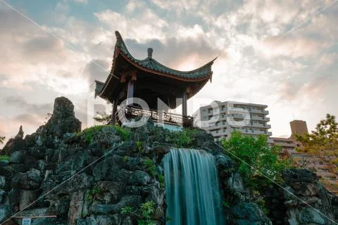 Photograph: Pagoda and waterfall in Fukushuen Chinese Garden in Naha ...