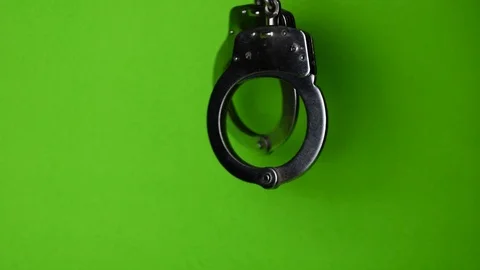 Pair of metal handcuffs over on green sc... | Stock Video | Pond5